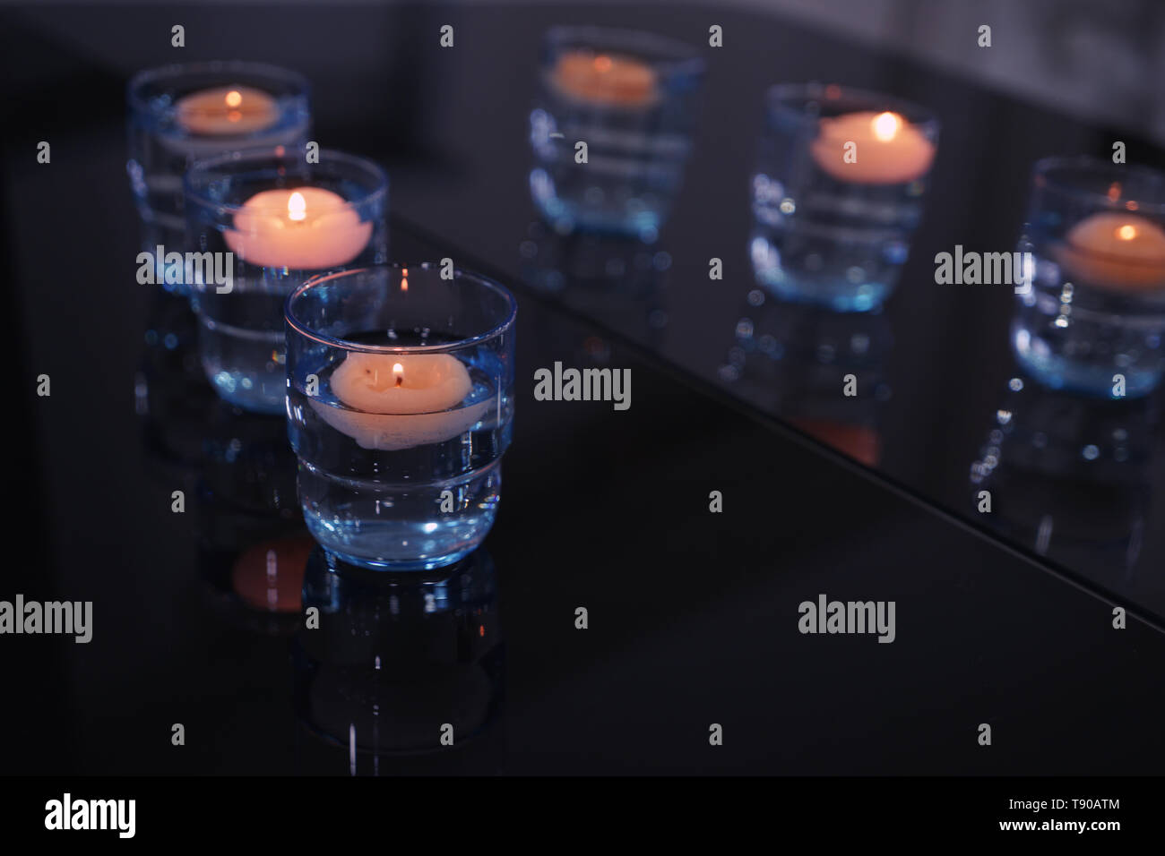 Beautiful burning candles on dark table Stock Photo - Alamy