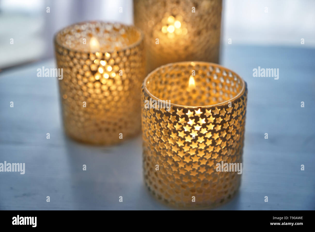 Beautiful burning candles in decorative holders on table Stock Photo ...