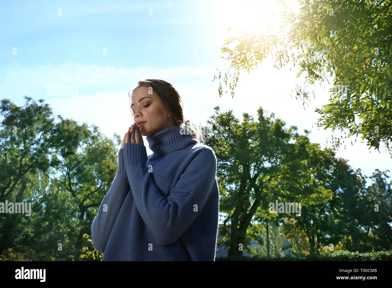Beautiful young woman praying outdoors Stock Photo - Alamy