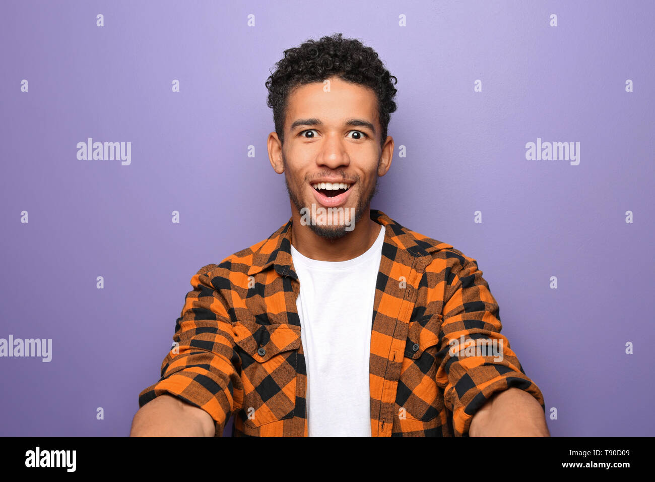 Portrait of surprised African-American man on color background Stock ...