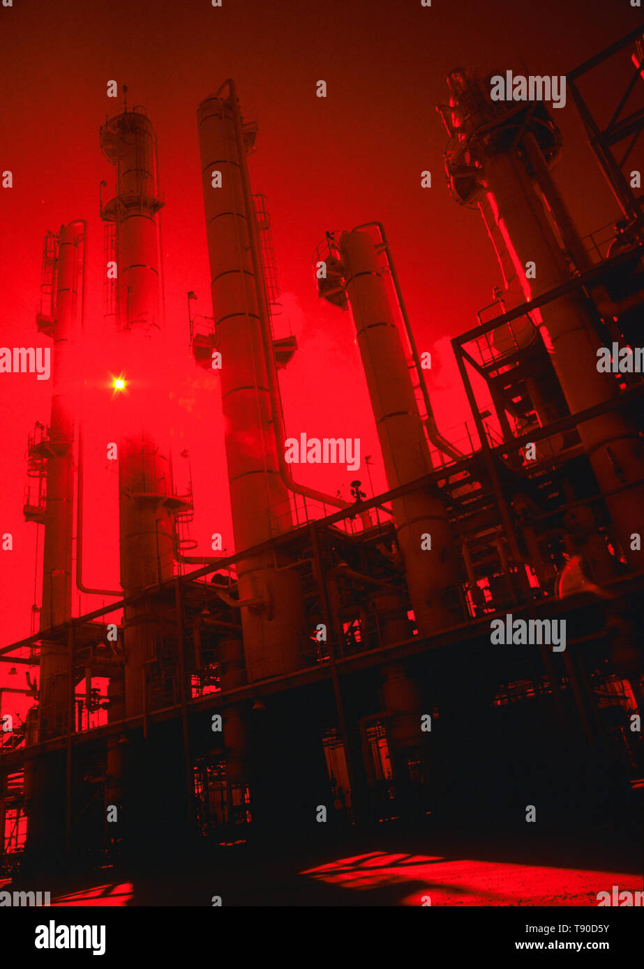 An oil refinery and the sun as seen through a red filter Stock Photo ...
