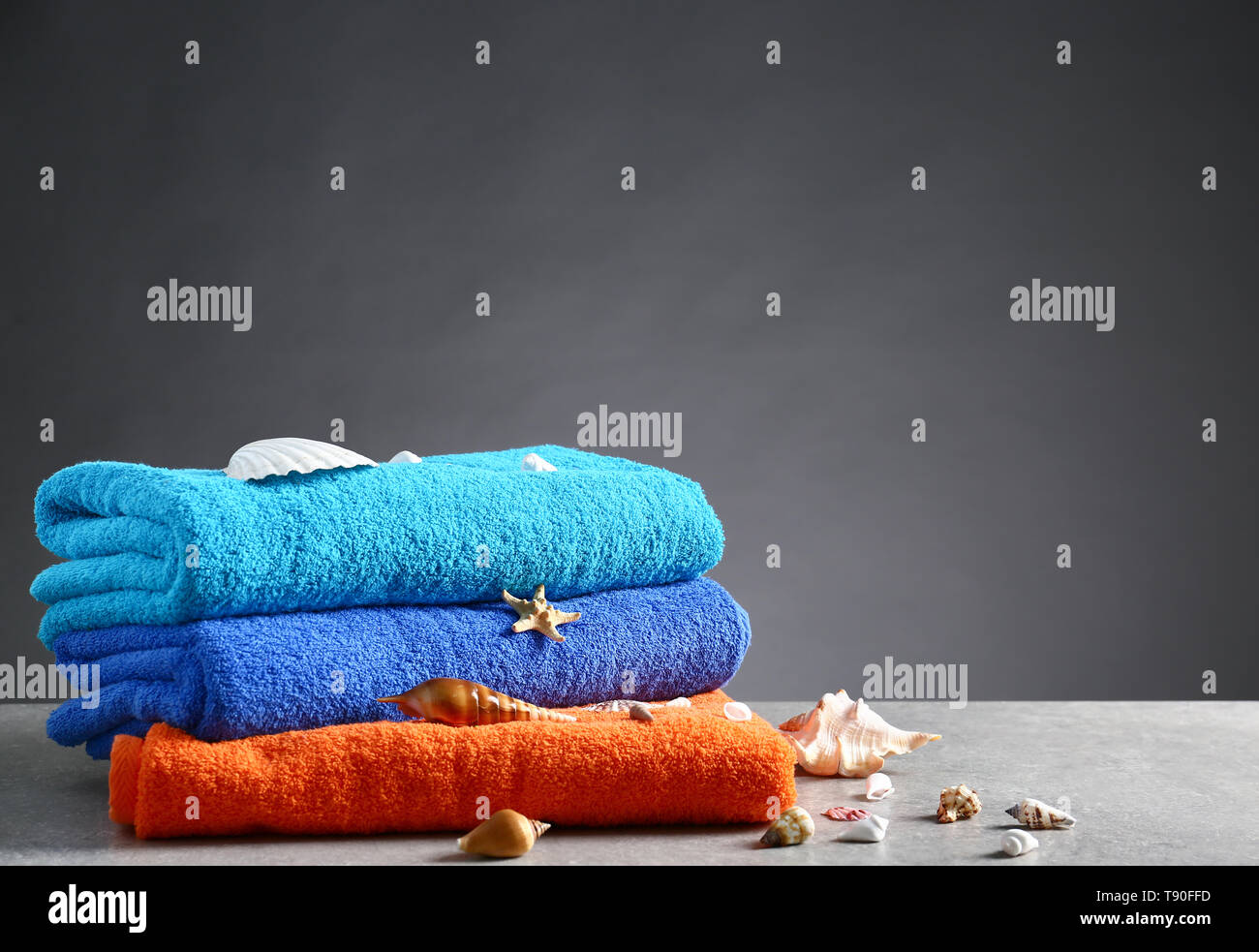 Tidy towels and seashells on grey table Stock Photo - Alamy