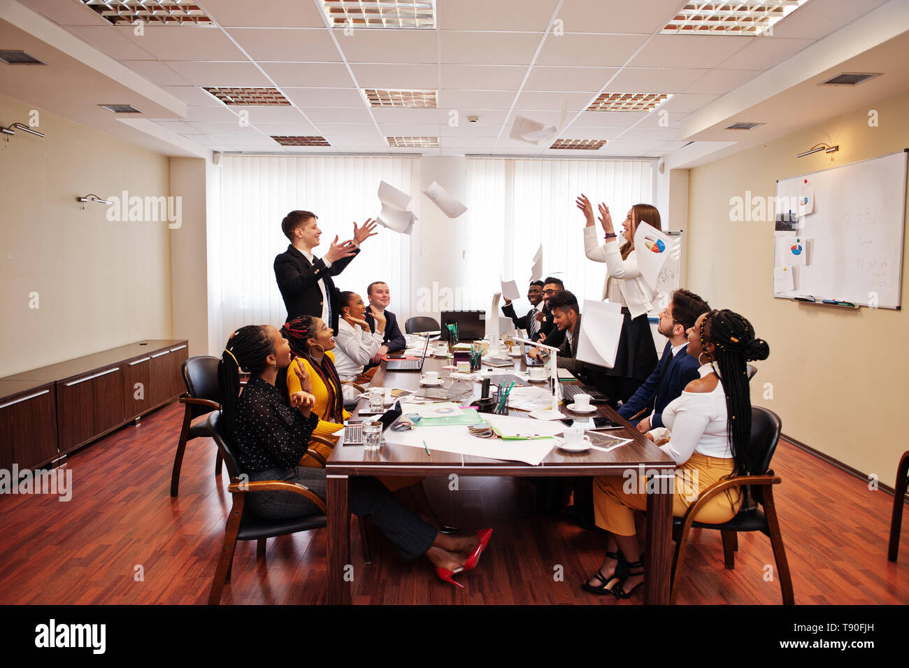 Multiracial business team meeting around boardroom table, two team ...