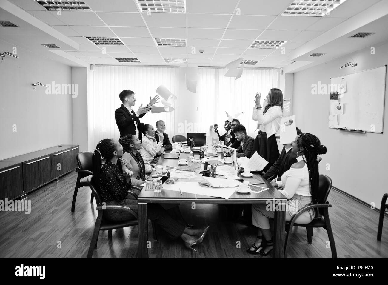 Multiracial business team meeting around boardroom table, two team ...