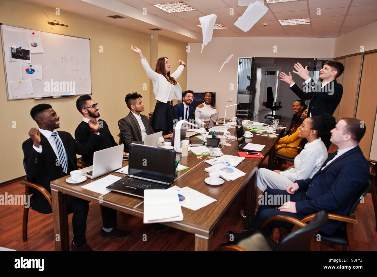 Multiracial business team meeting around boardroom table, two team ...