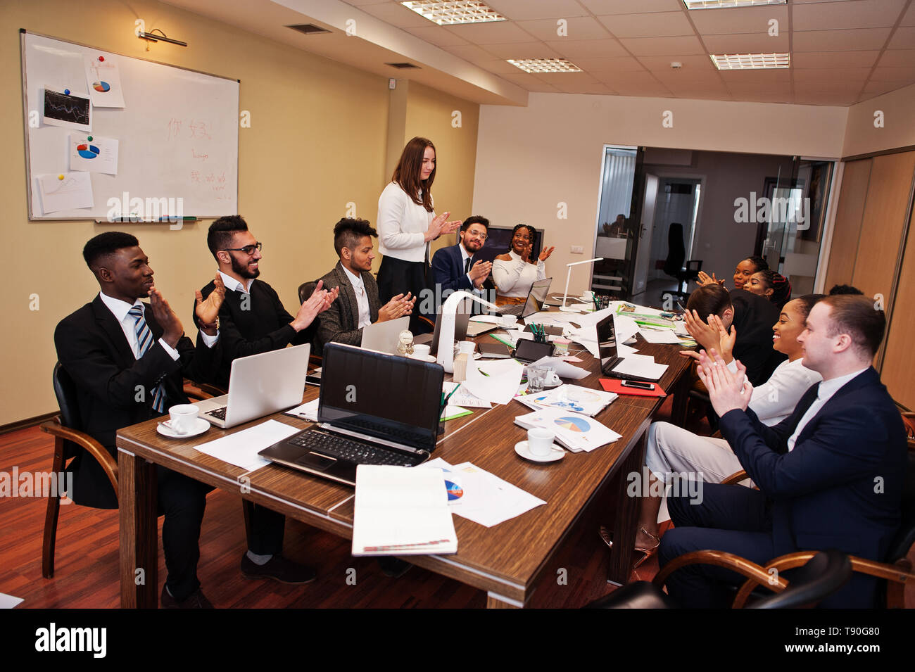 Multiracial business team meeting around boardroom table, clap hands ...
