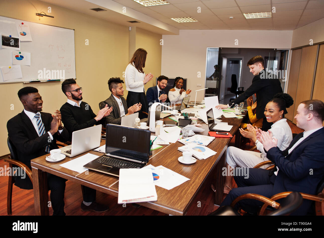 Multiracial business team meeting around boardroom table, clap hands ...