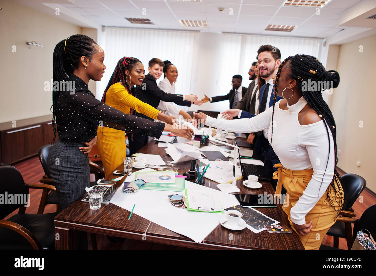 Good deal. Multiracial business team addressing meeting around ...