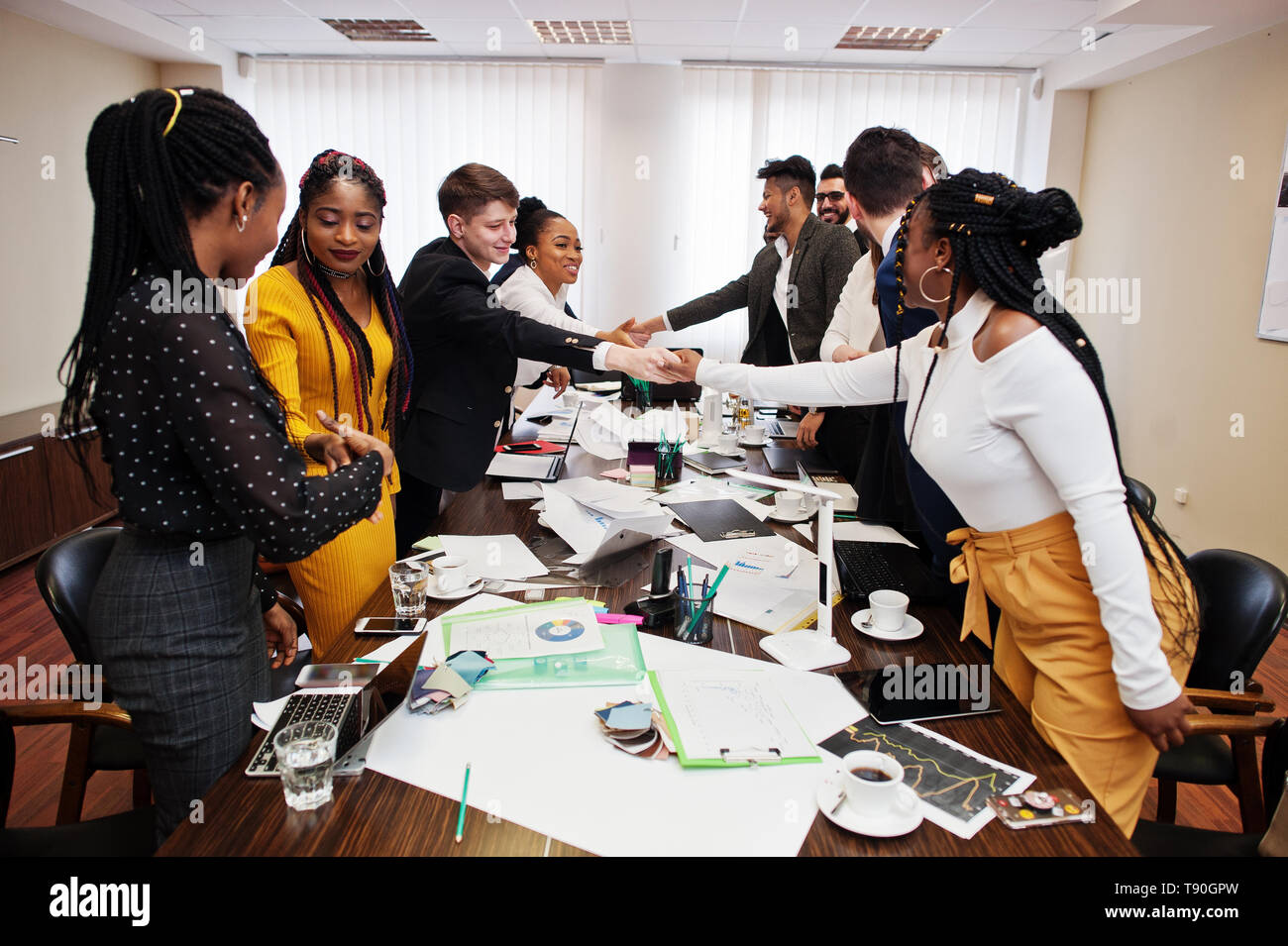 Good deal. Multiracial business team addressing meeting around ...