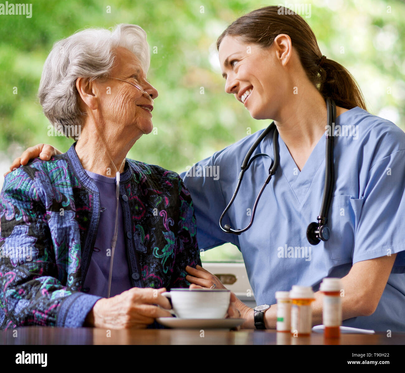 Smiling senior woman being comforted by a female nurse Stock Photo - Alamy
