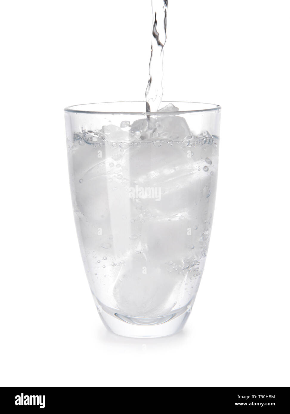 Pouring of water in glass with ice on white background Stock Photo - Alamy