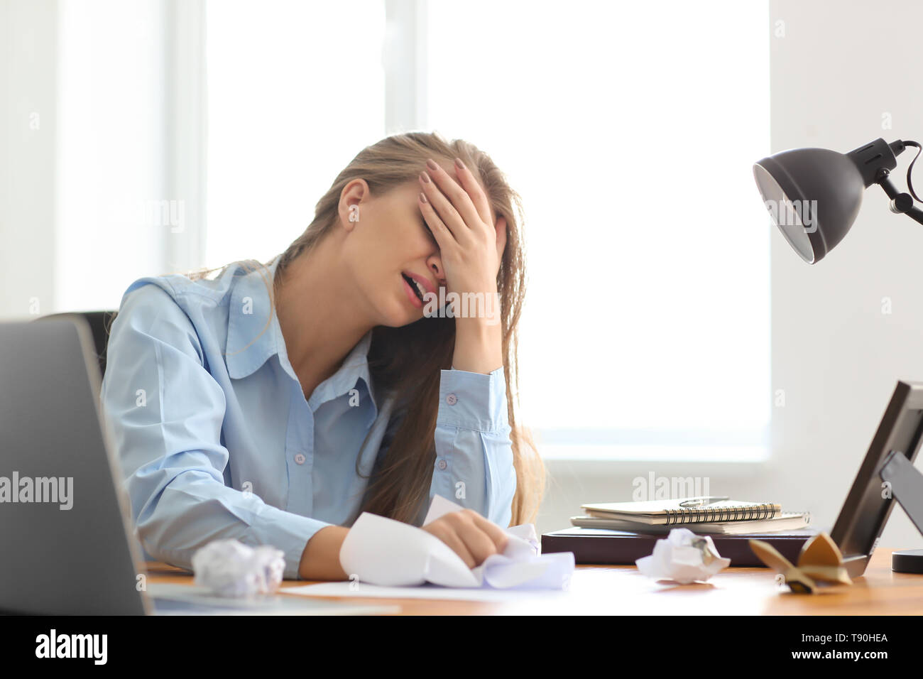 Stressed young woman at workplace Stock Photo - Alamy