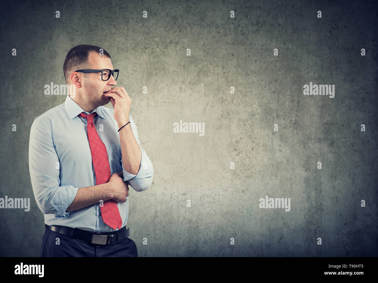 Business man in glasses biting nails being in panic and anxiety looking ...