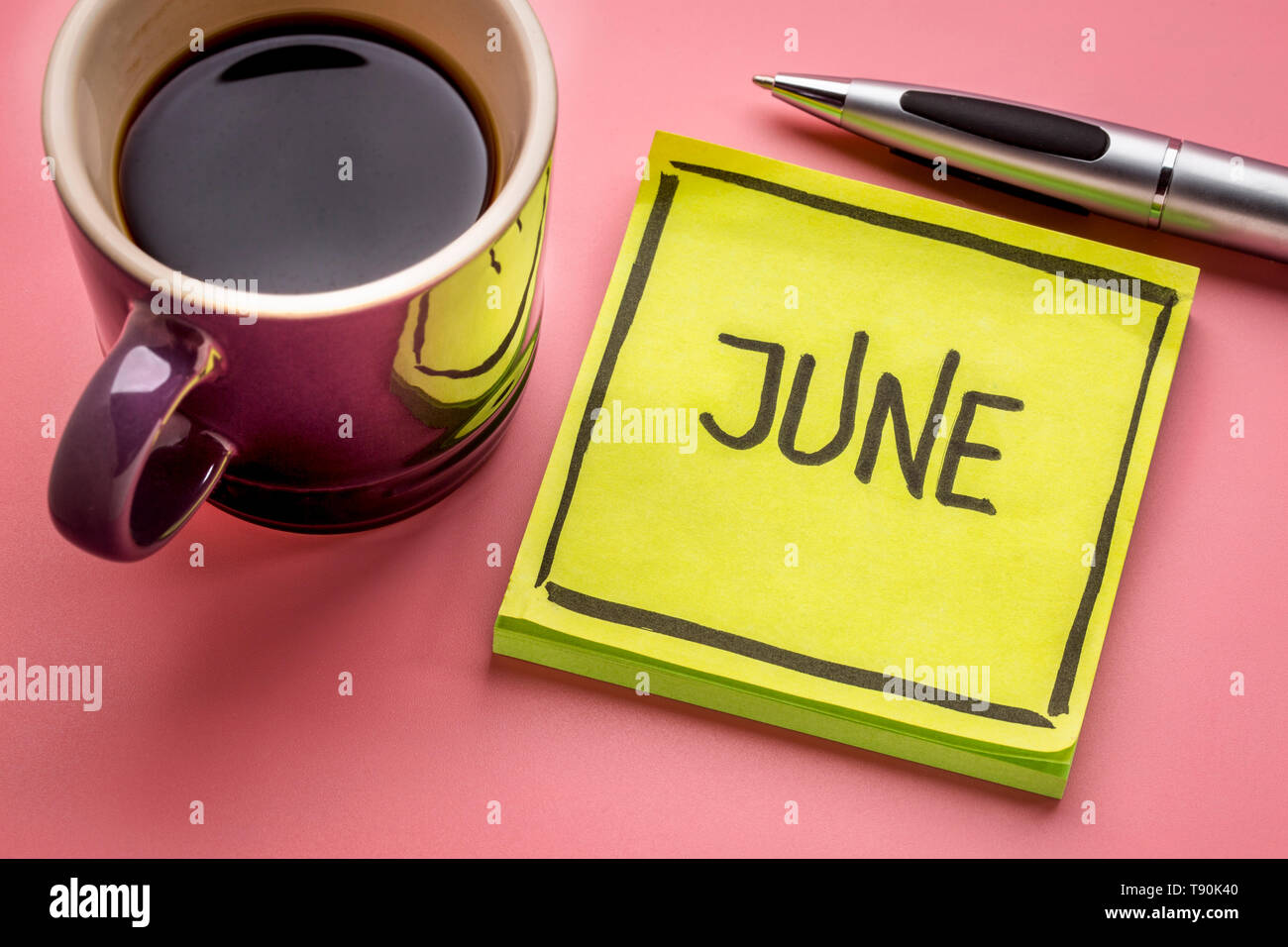 June - handwriting in black ink on a sticky note with a cup of coffee ...
