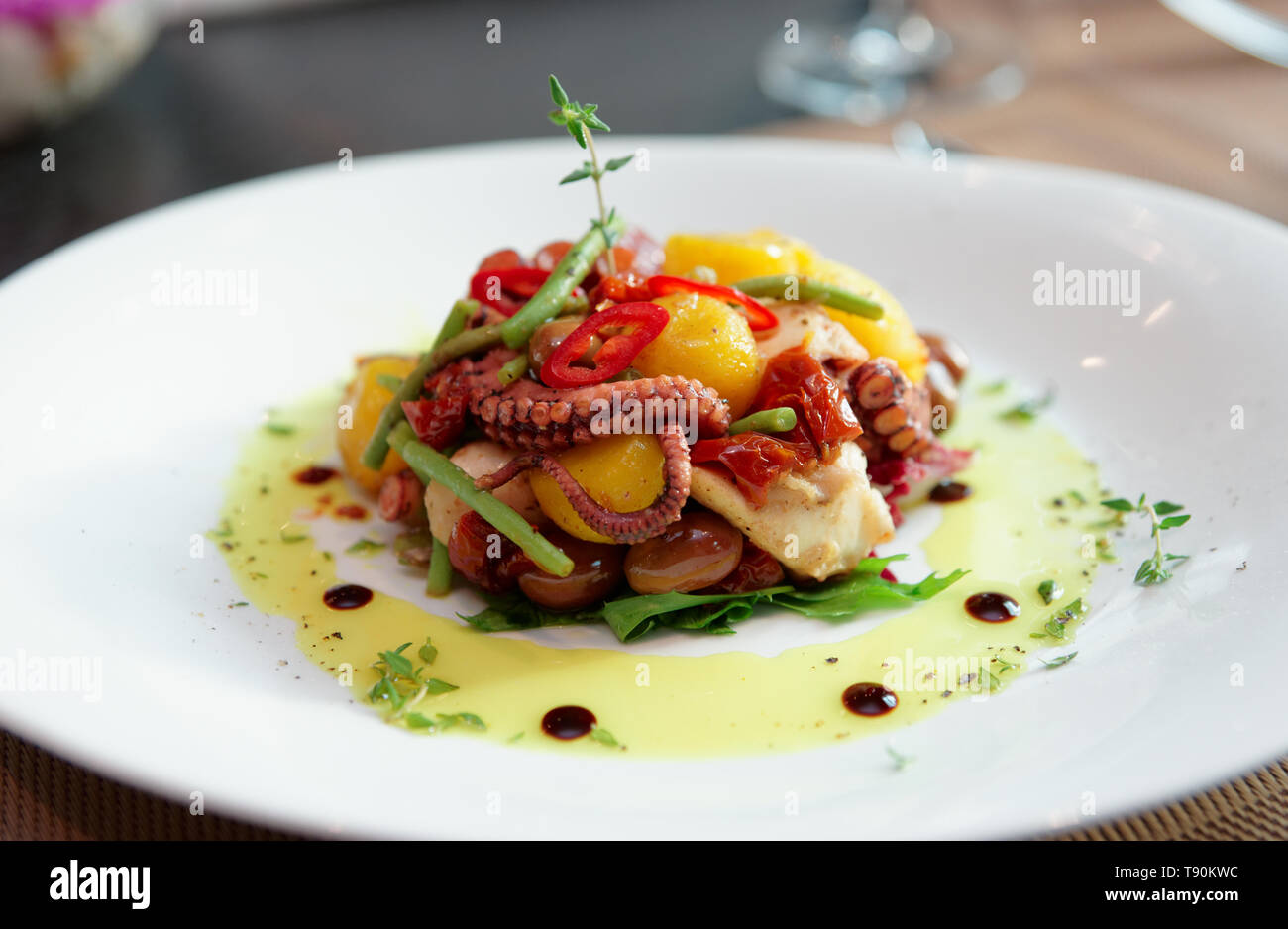 Appetizer with grilled octopus, potatoes and vegetables on plate Stock ...