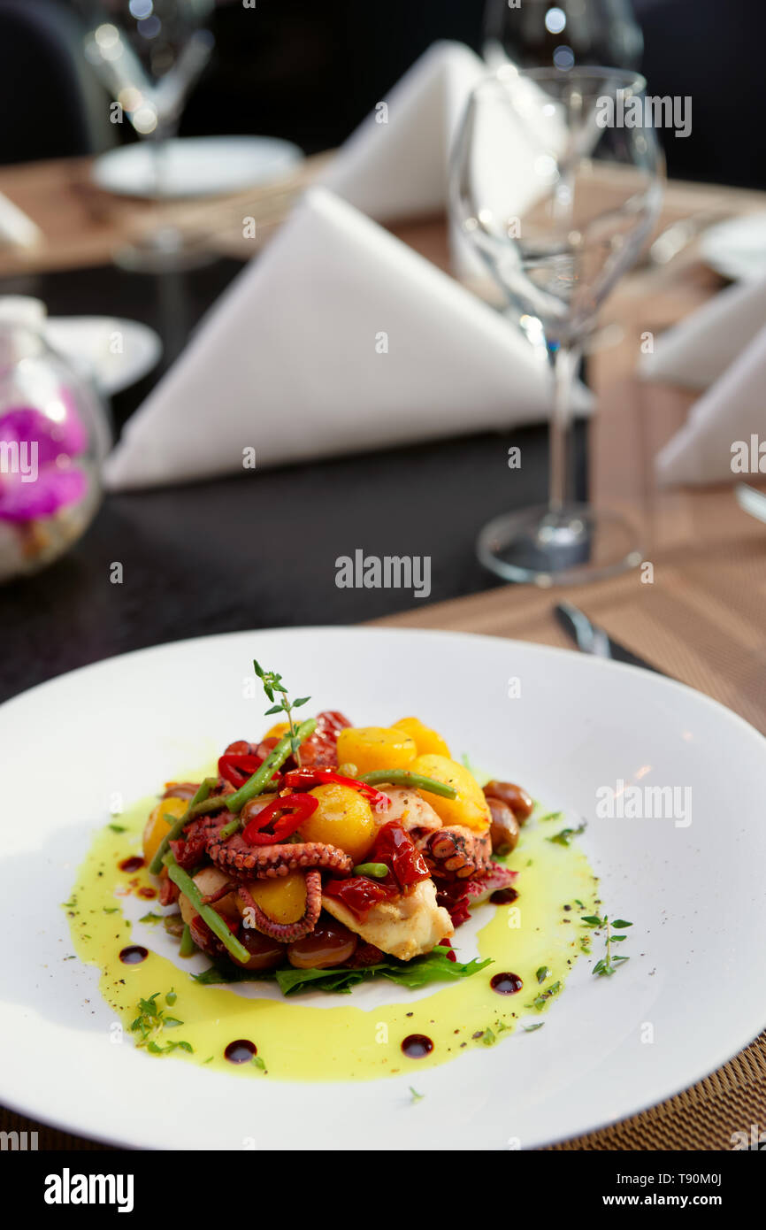 Appetizer with grilled octopus, potatoes and vegetables on restaurant ...