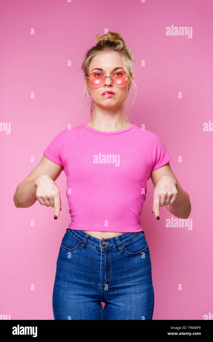 Image of smiling blonde in pink glasses pointing finger down Stock ...