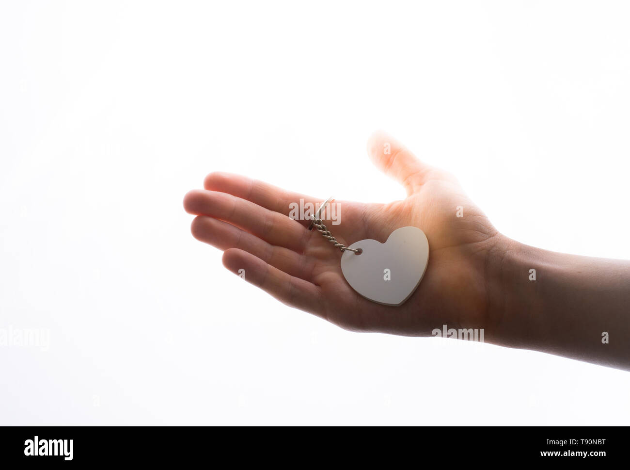 Heart shaped white object in hand on white background Stock Photo - Alamy