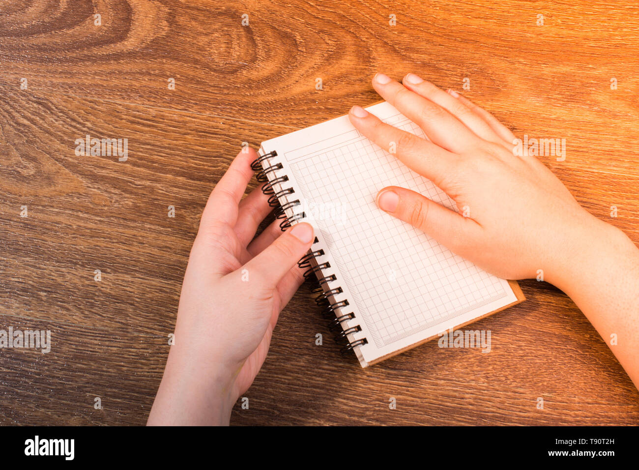 White notebook in hand on a brown color background Stock Photo - Alamy