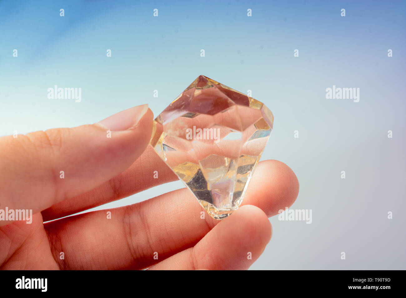 Hand holding a transparent diamond on a white background Stock Photo ...