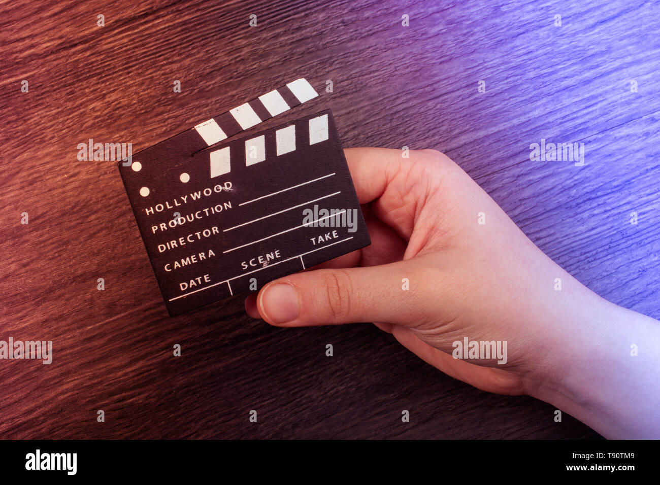 Hand holding movie clapper on a dark background Stock Photo - Alamy