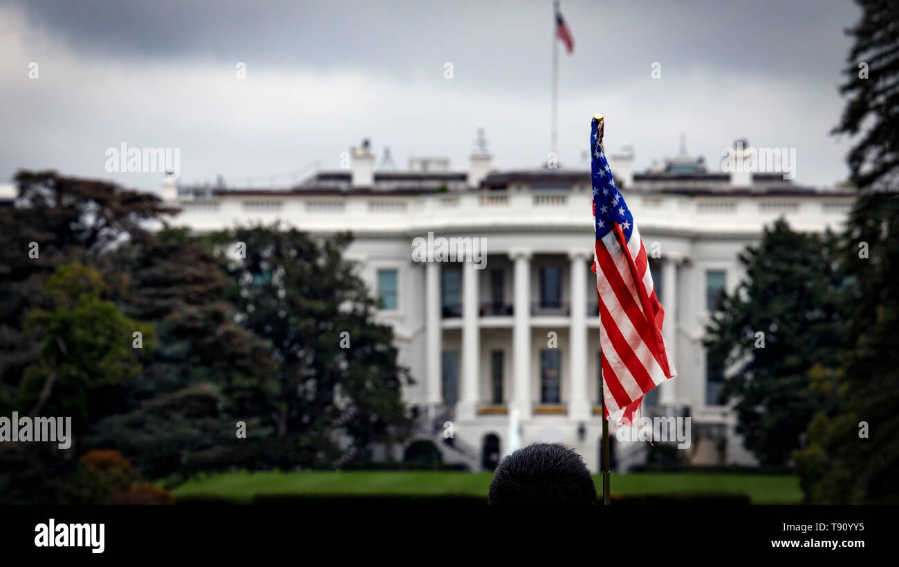 The American flag of a tourist standing in front of the White House in ...
