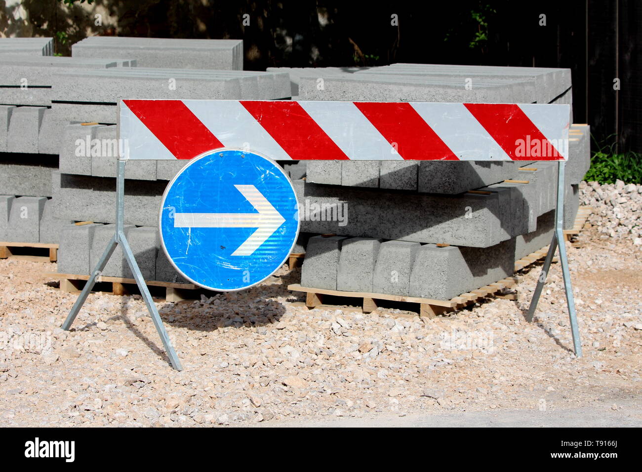 Construction site road signs directing traffic away from concrete curbs ...
