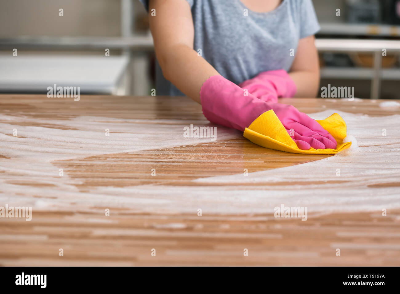 Woman cleaning wooden table at home Stock Photo - Alamy