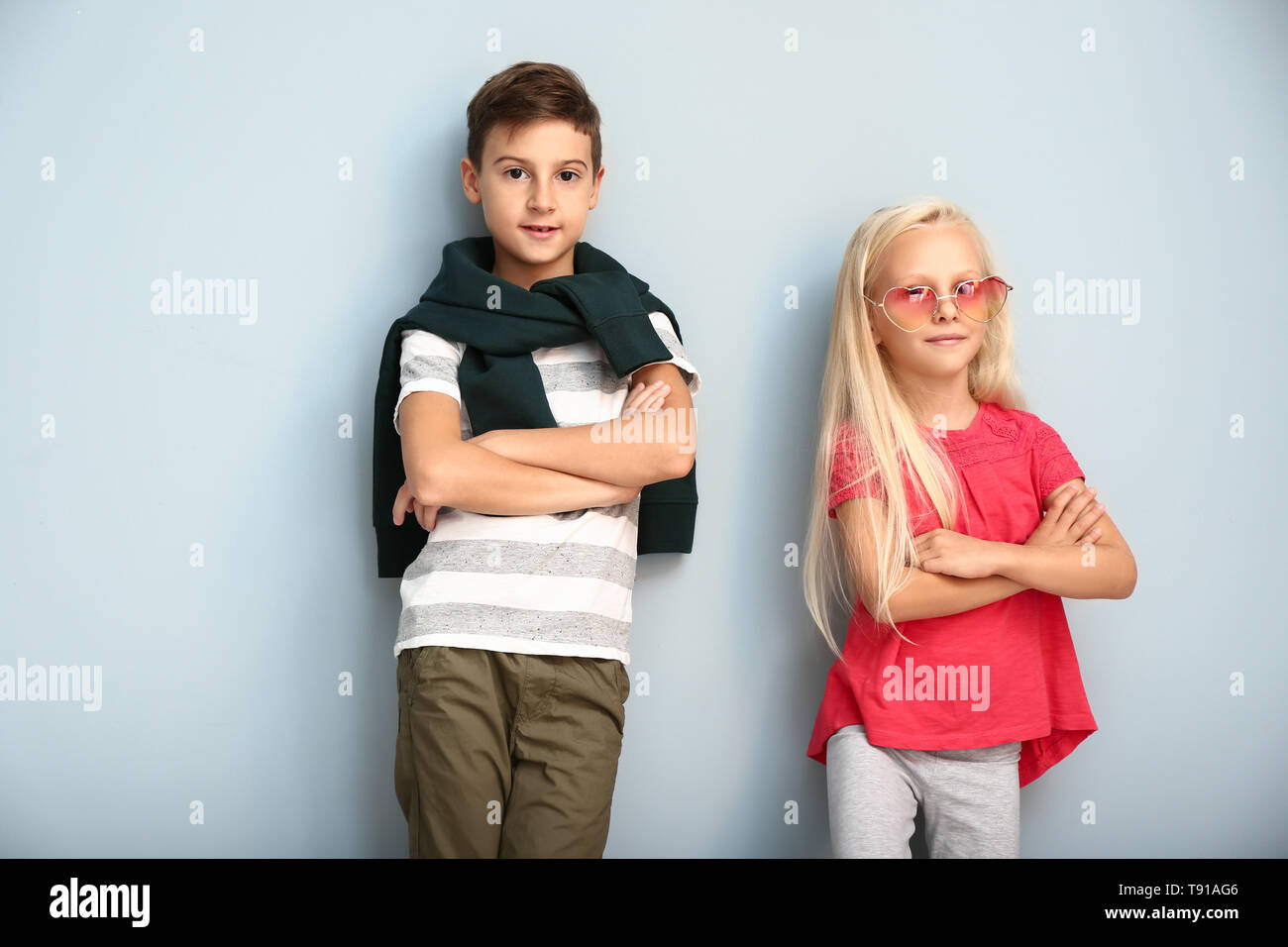 Cute boy and girl in fashionable clothes on color background Stock ...