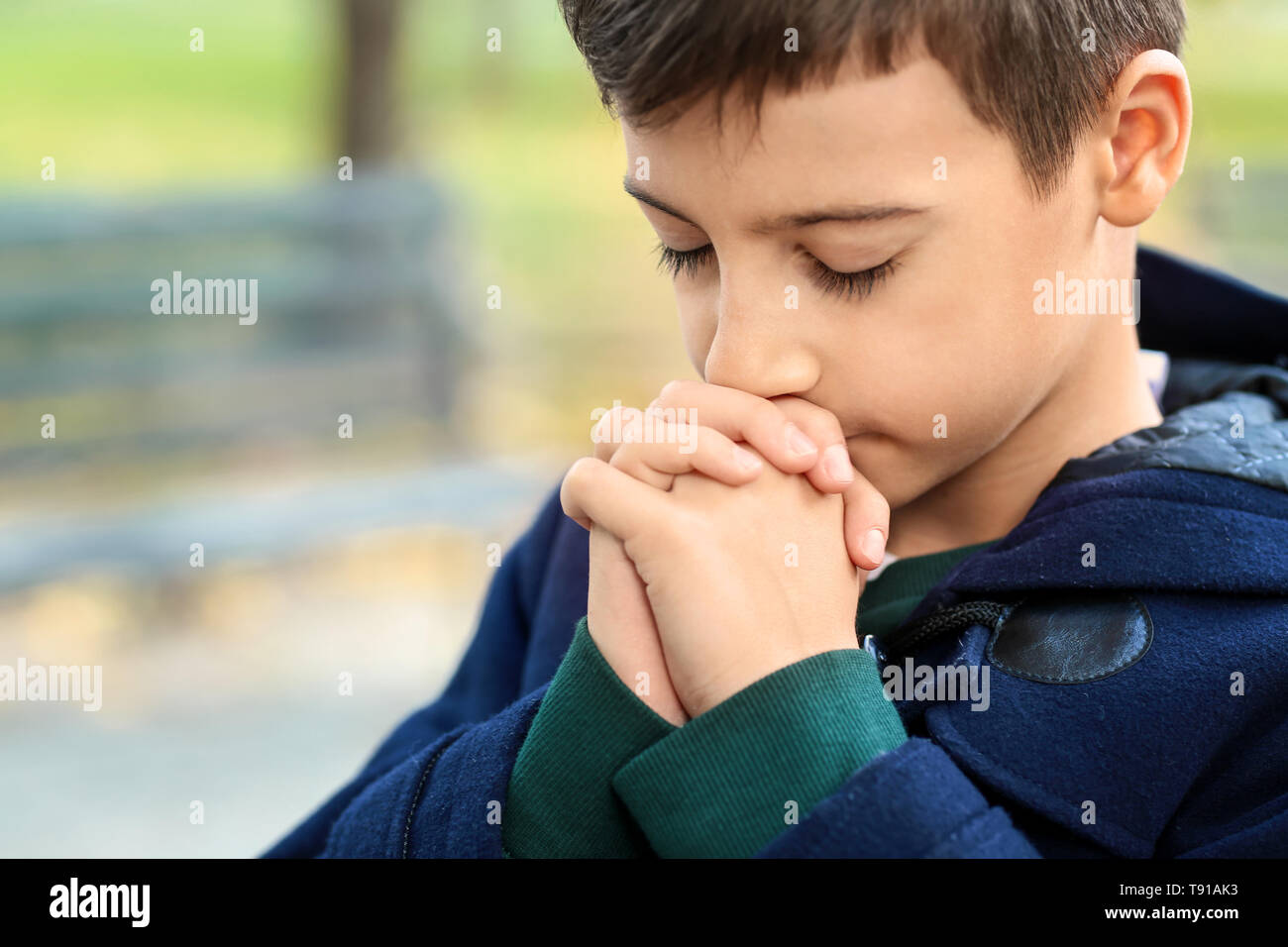 Little boy praying outdoors Stock Photo - Alamy