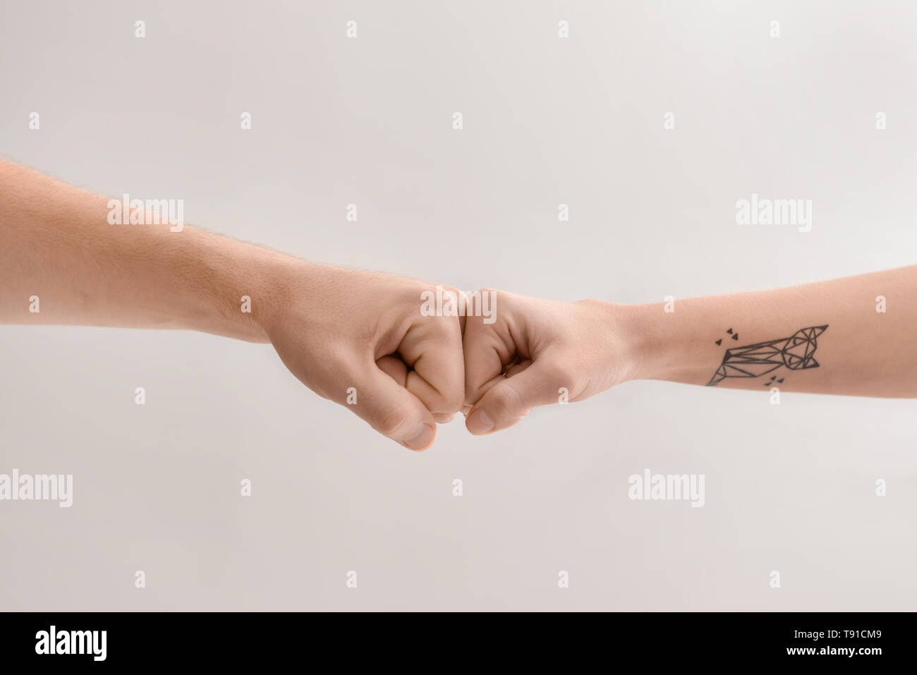 Man and woman making fist bump gesture on light background Stock Photo ...