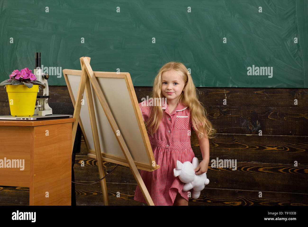 Creative little girl painting on studio easel. Creative artist at work ...