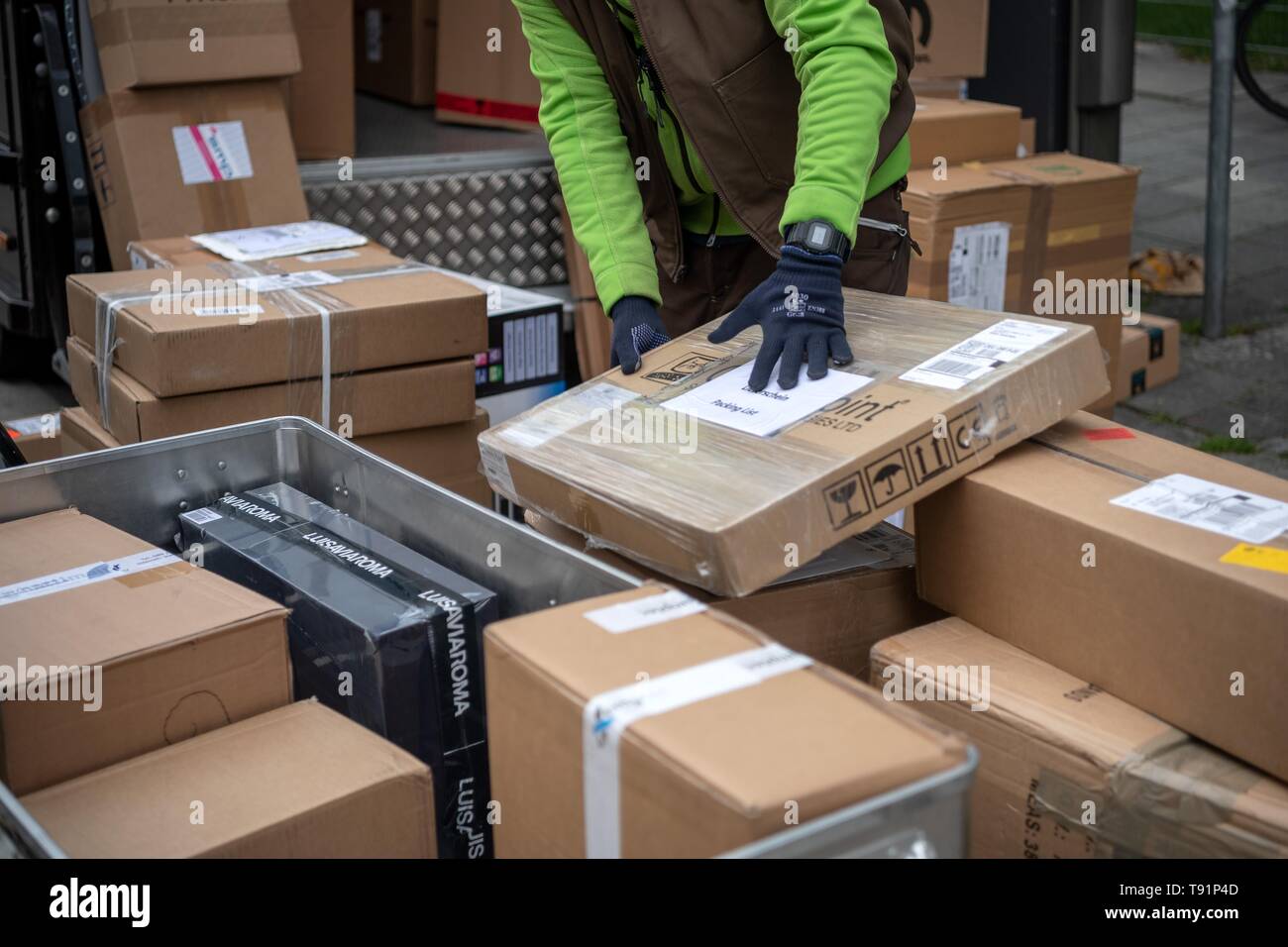 15 May 2019, Bavaria, Munich: A parcel carrier from UPS loads parcels ...
