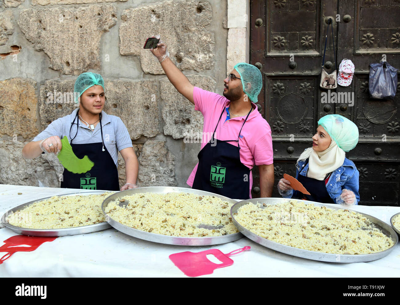 Damascus, Syria. 14th May, 2019. Volunteers prepare food at a charity ...