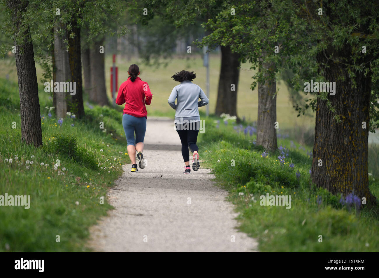 Munich, Deutschland. 16th May, 2019. Two women are jogging on a gravel ...
