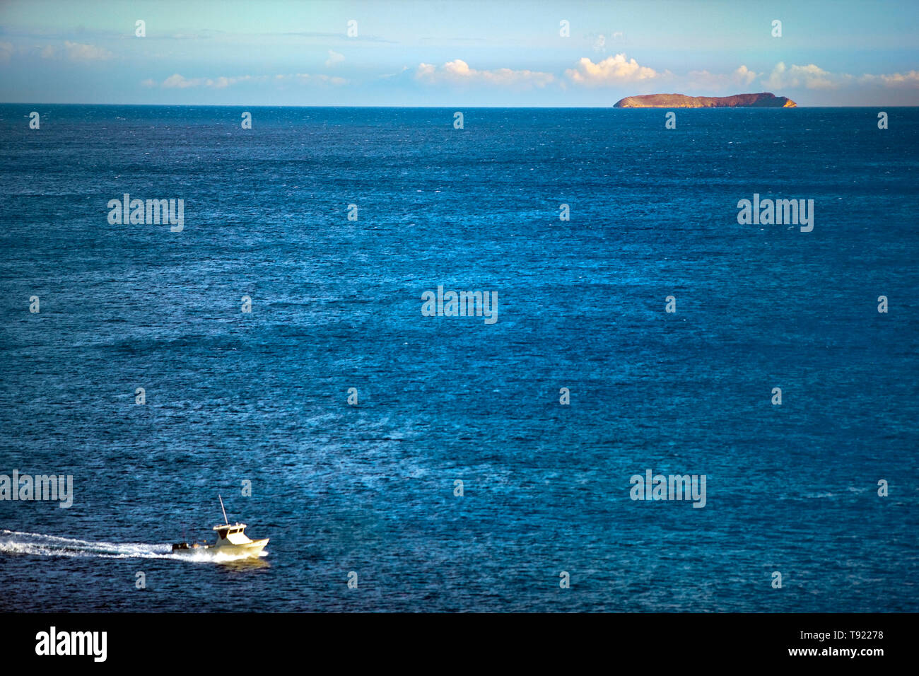 Fishing boat moves across the sea past an island on the horizon Stock ...