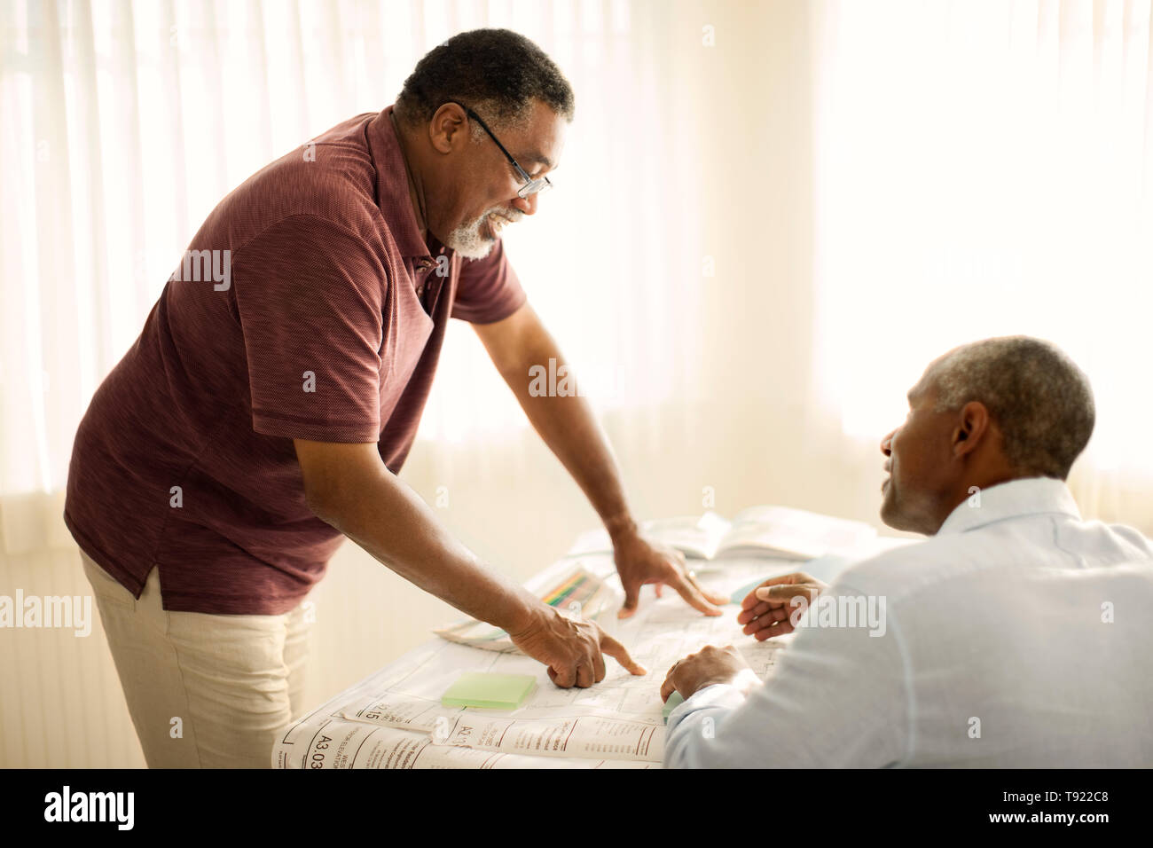 Father offering his adult son advice on home renovations Stock Photo ...