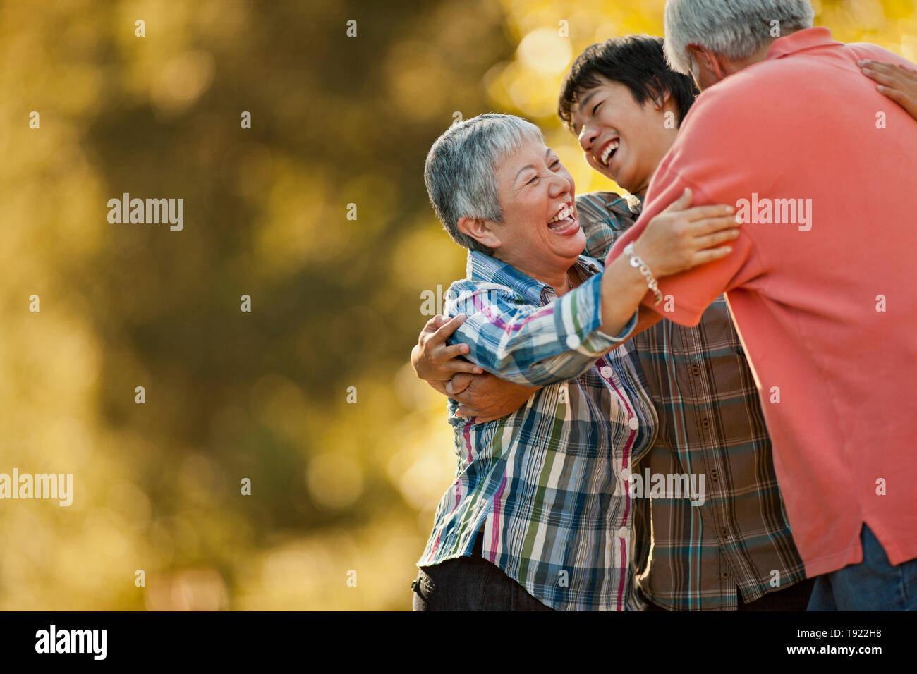 Smiling teenage boy hugging his grandparents Stock Photo - Alamy