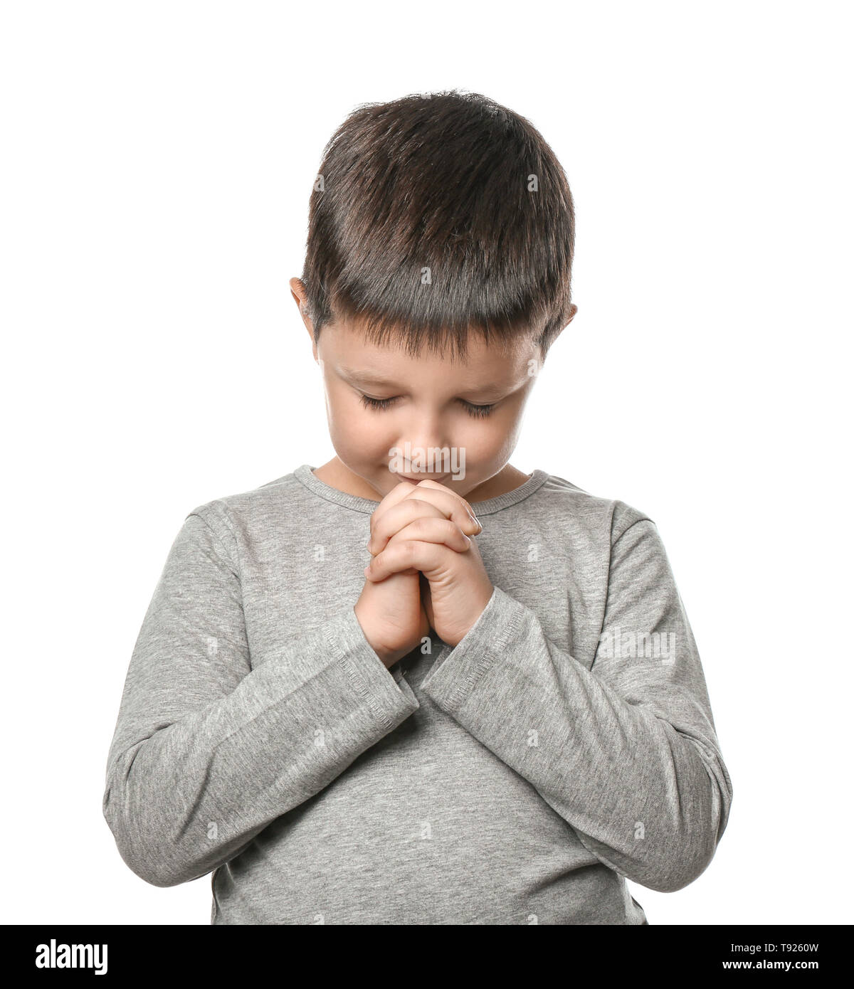 Little boy praying on white background Stock Photo - Alamy