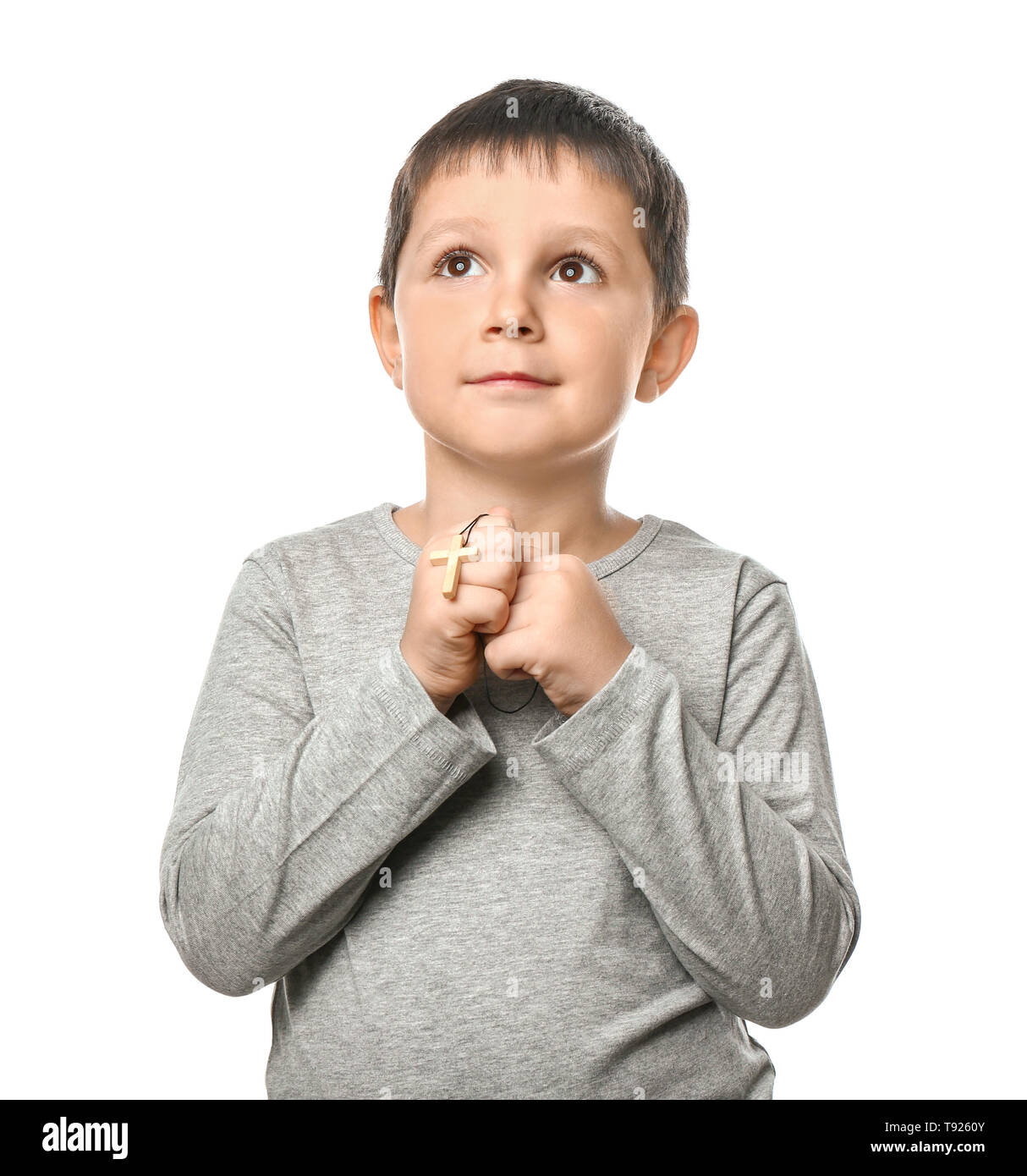 Little boy with cross praying on white background Stock Photo - Alamy