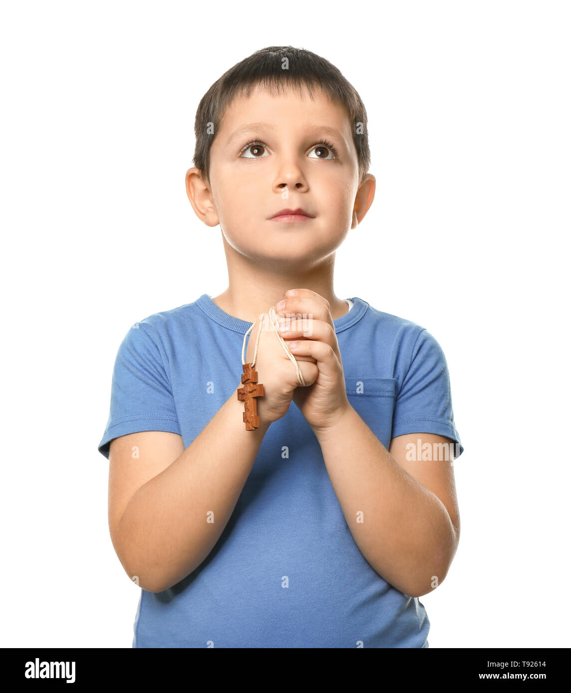 Little boy with cross praying on white background Stock Photo - Alamy
