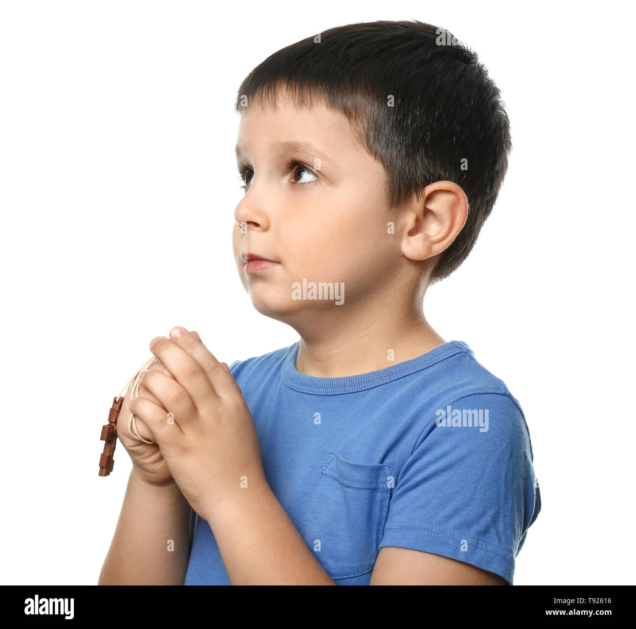 Little boy with cross praying on white background Stock Photo - Alamy