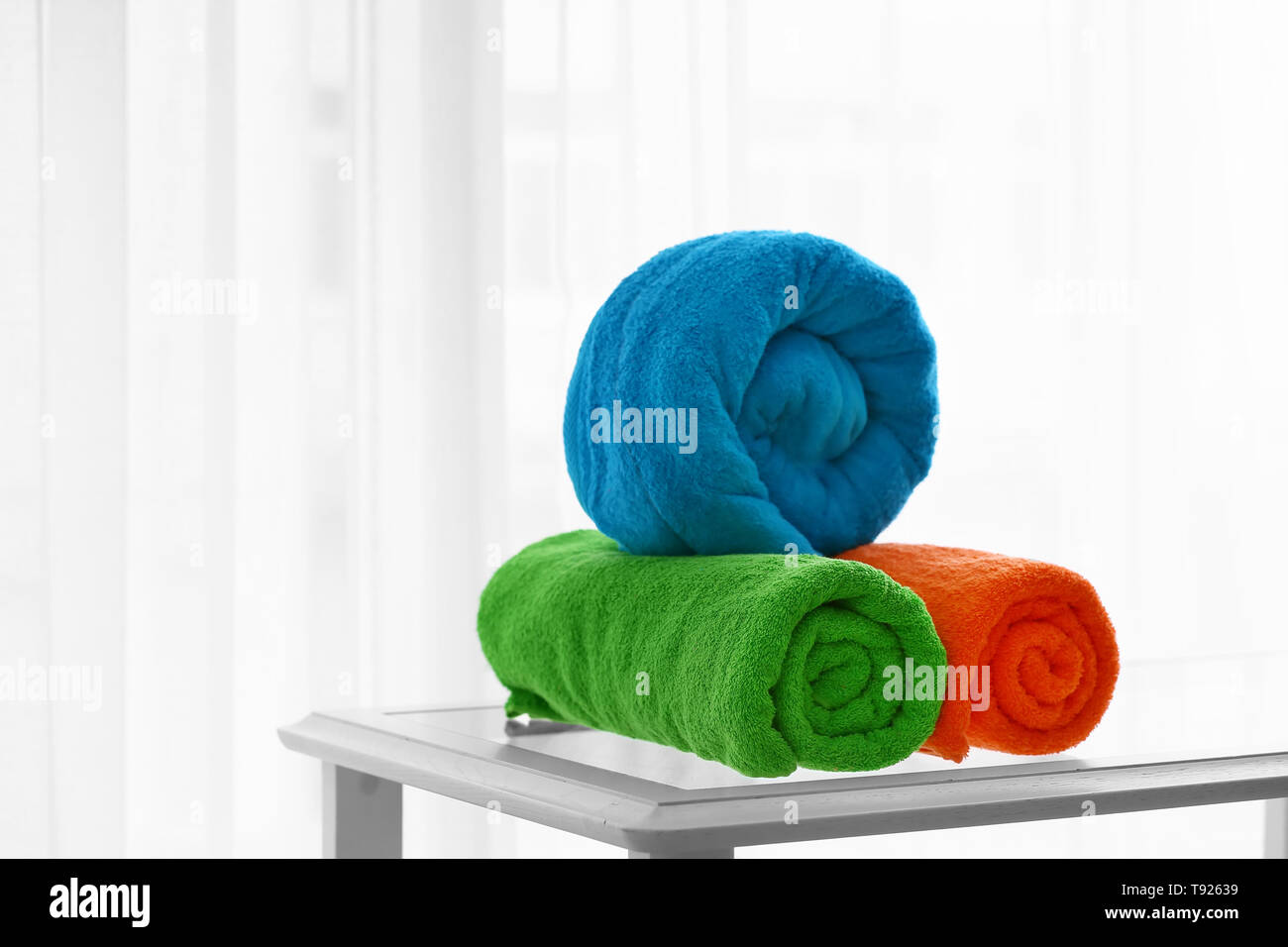 Rolled bright terry towels on table Stock Photo - Alamy