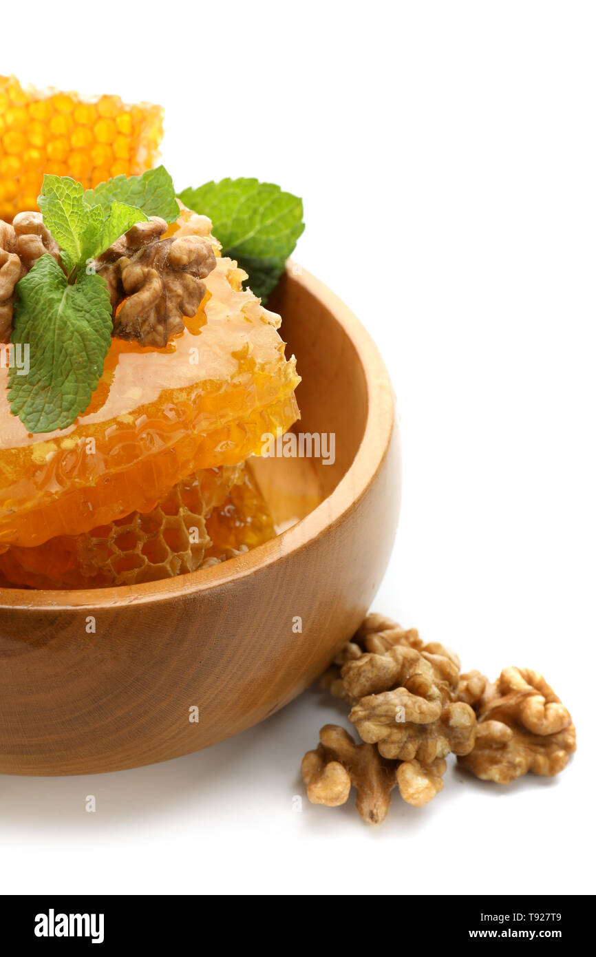 Wooden bowl with honeycomb, mint and nuts on white background Stock ...
