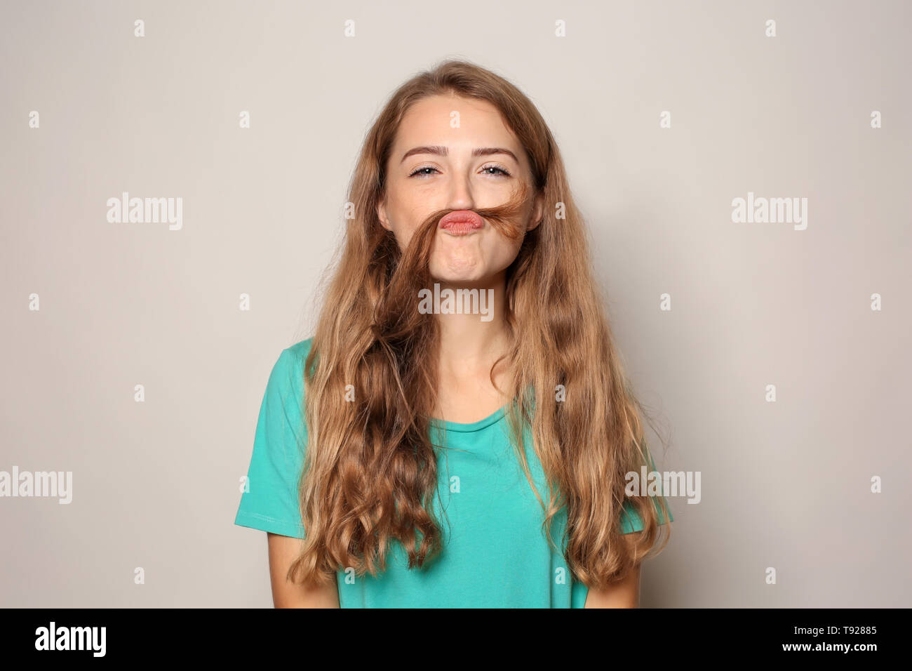 Portrait of funny young woman on light background Stock Photo - Alamy