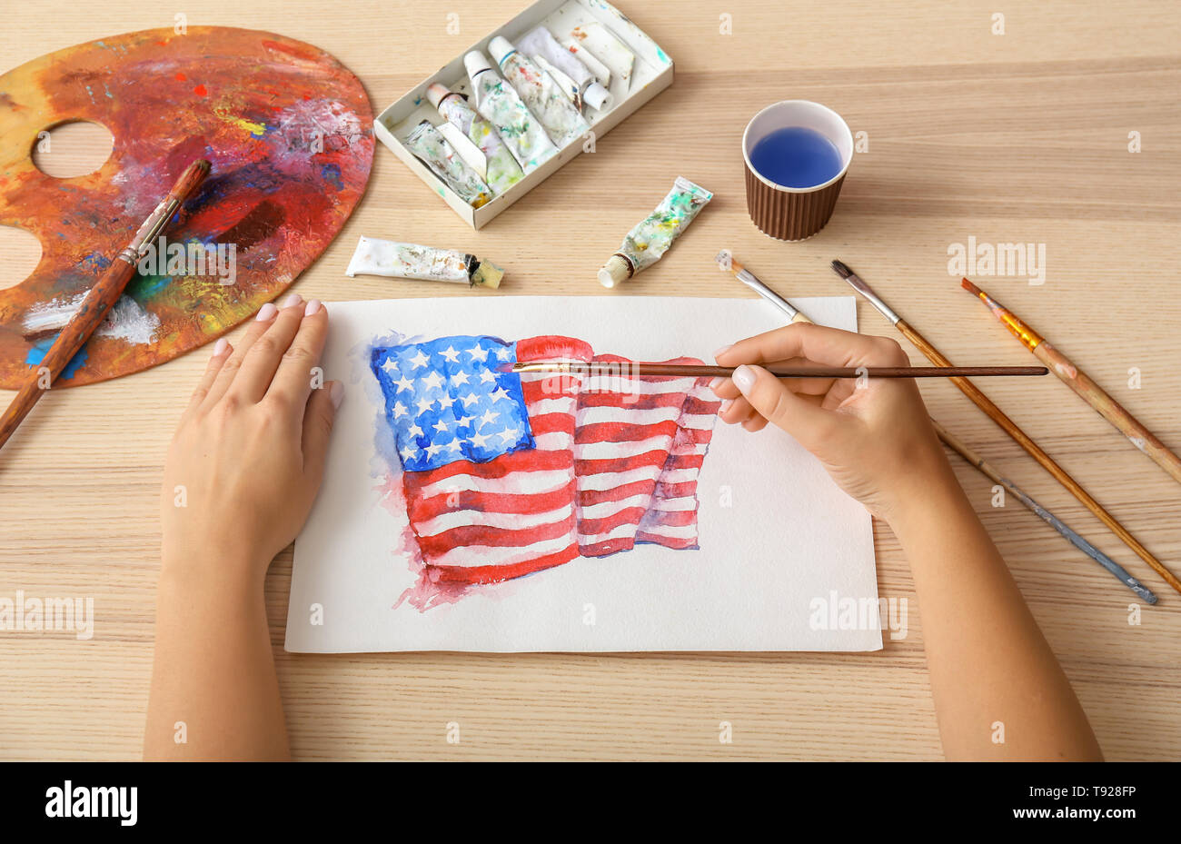Woman painting American national flag on sheet of paper Stock Photo - Alamy