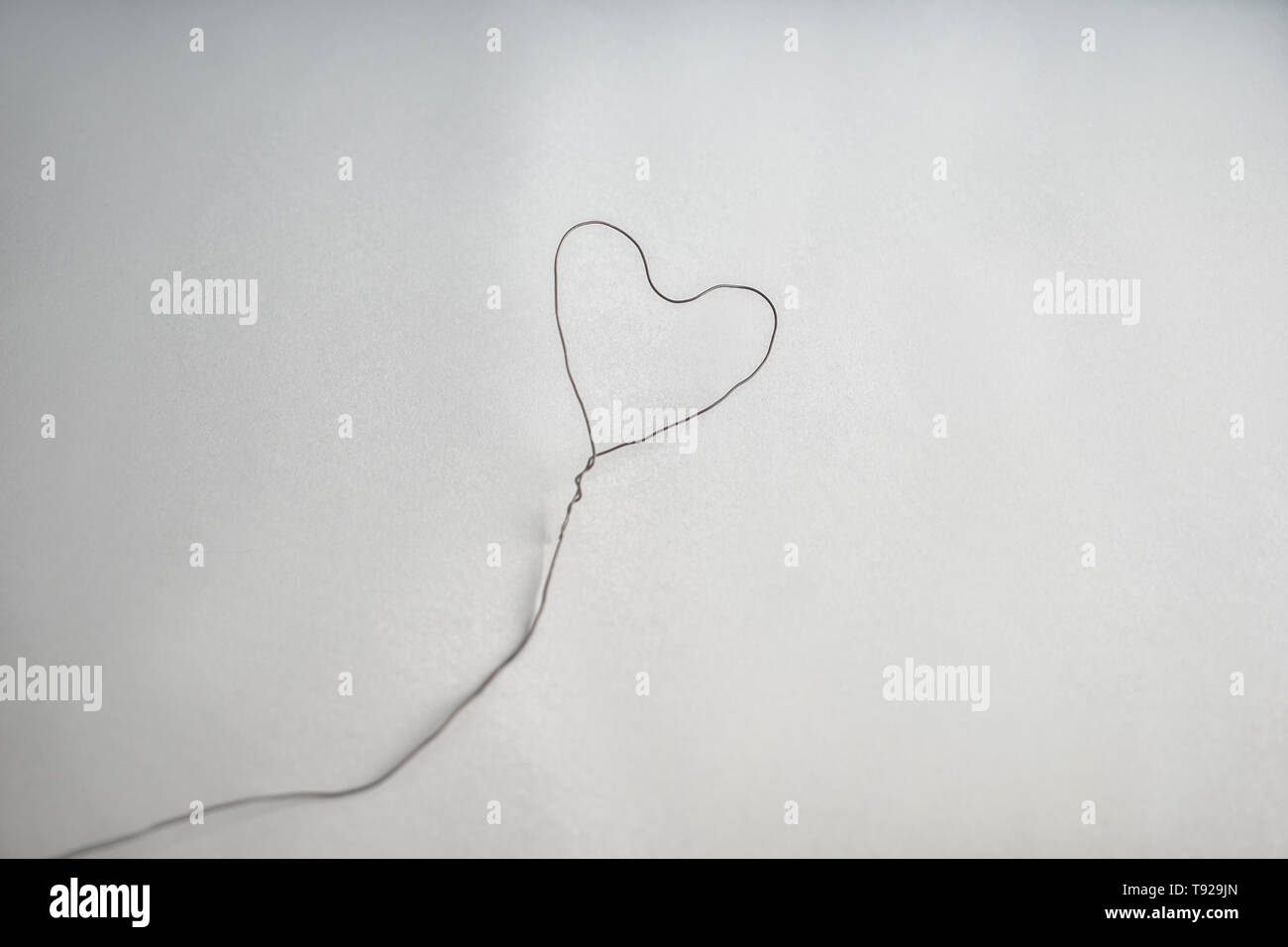 Heart made of wire on grey background Stock Photo - Alamy