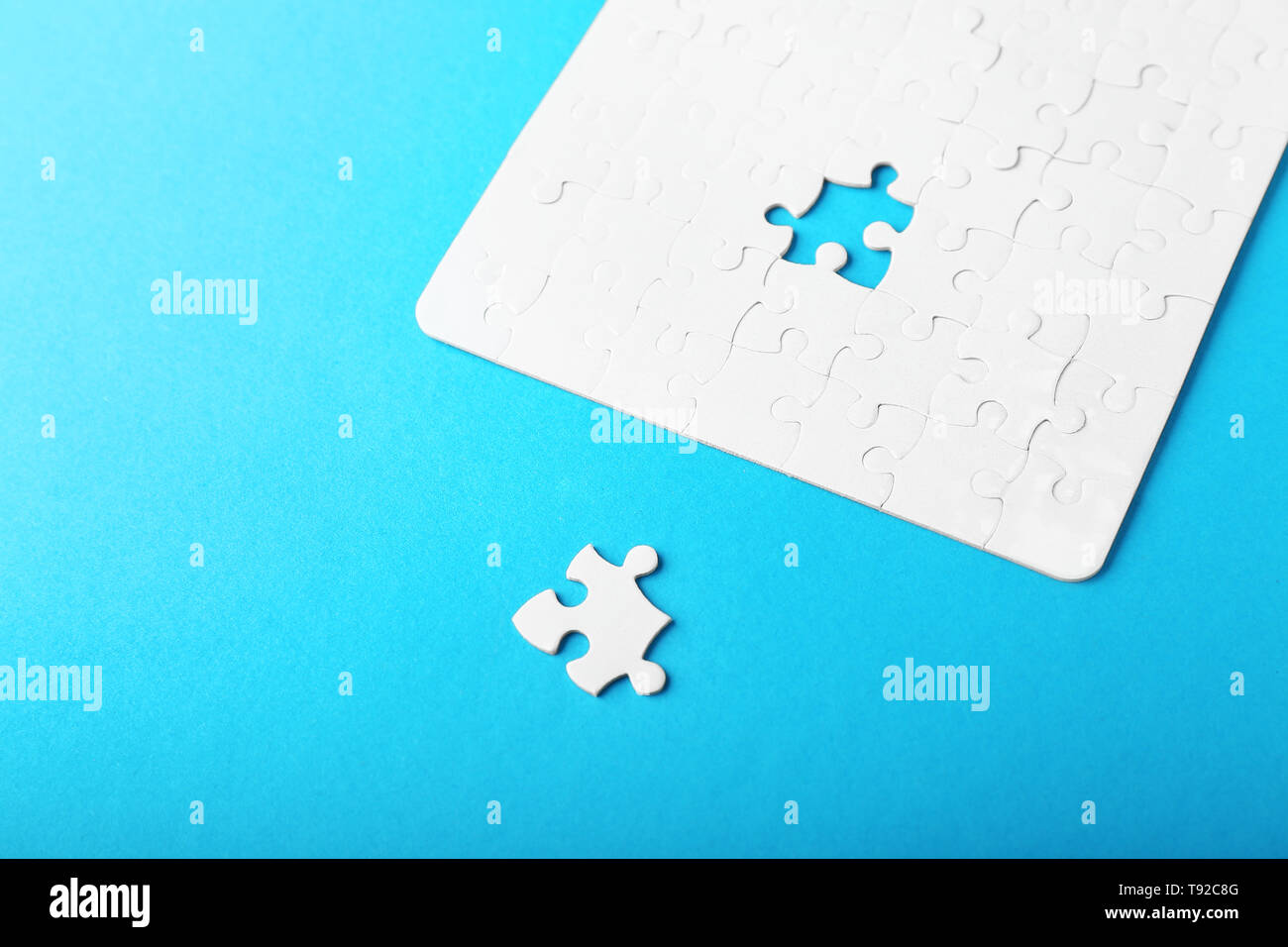 White jigsaw puzzle with piece on color background Stock Photo - Alamy