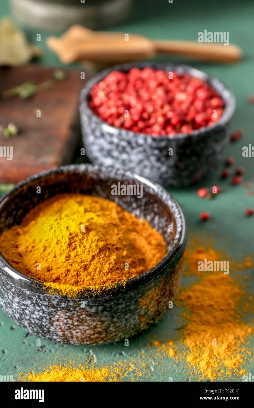 Bowl with turmeric powder on color table Stock Photo - Alamy