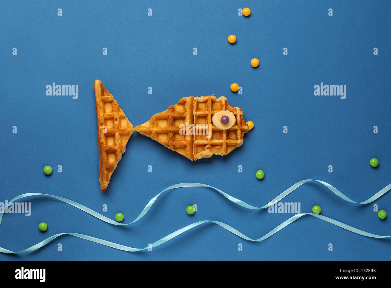 Creative composition with fish made of waffles on color background ...